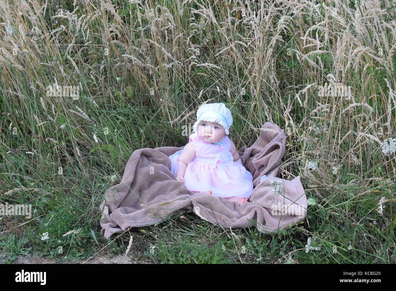 Baby in grass Stock Photo - Alamy