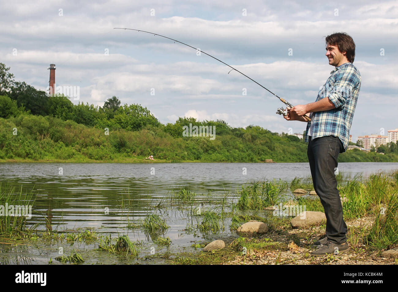 A man with a beard is fishing in the river Stock Photo - Alamy