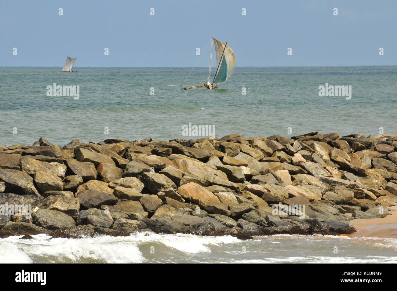 Traditional boat sailing off the beach on a Western shoreline of Sri ...