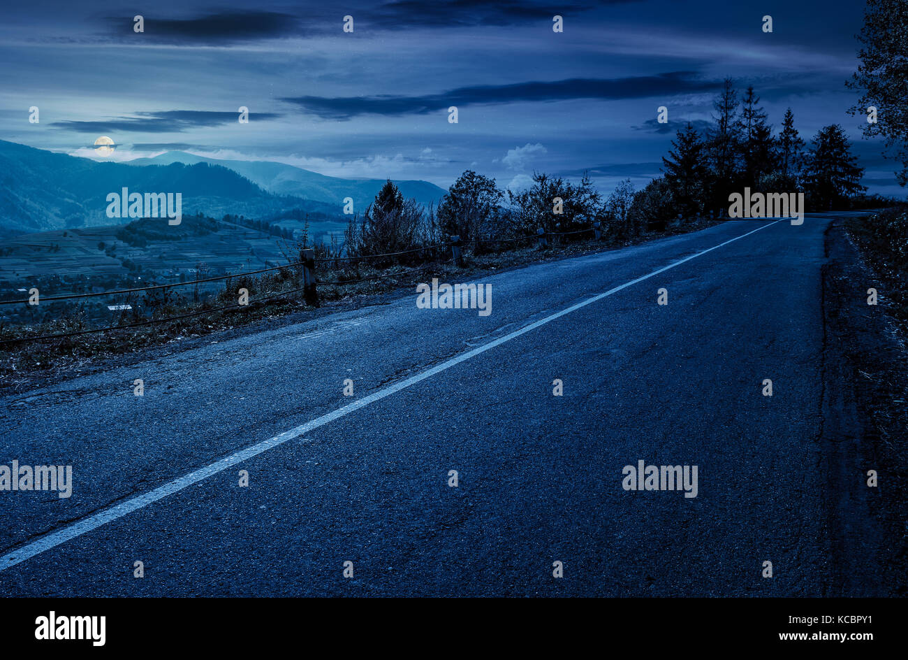 countryside road through mountains at night in full moon light. lovely ...