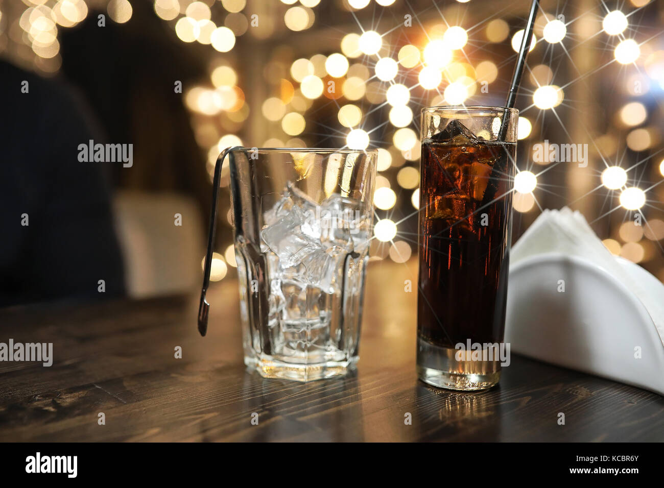 glass of cold alcohol drink with ice on table Stock Photo - Alamy