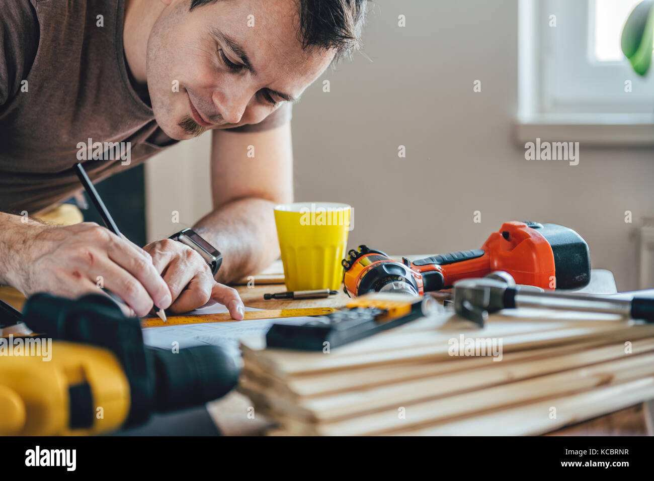 Man making draft plan with pencil on the table with power drills and ...