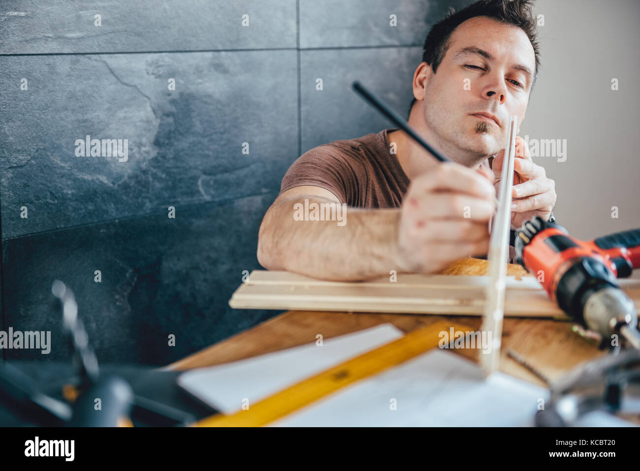 Man marking wood at home during renovation of living room Stock Photo ...