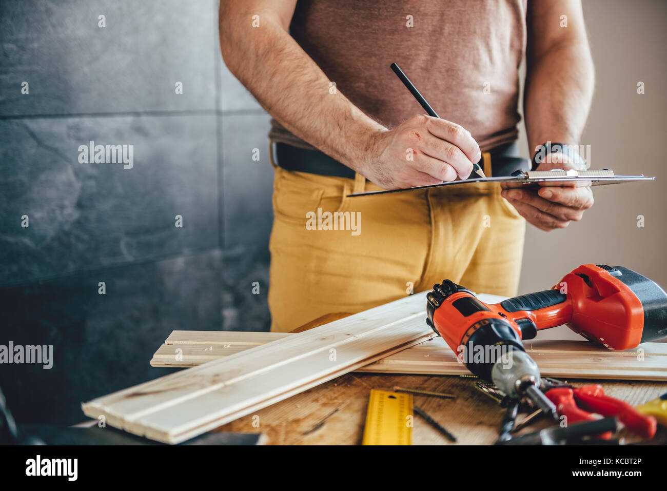 Man making draft plan with pencil on the table with power drills and ...