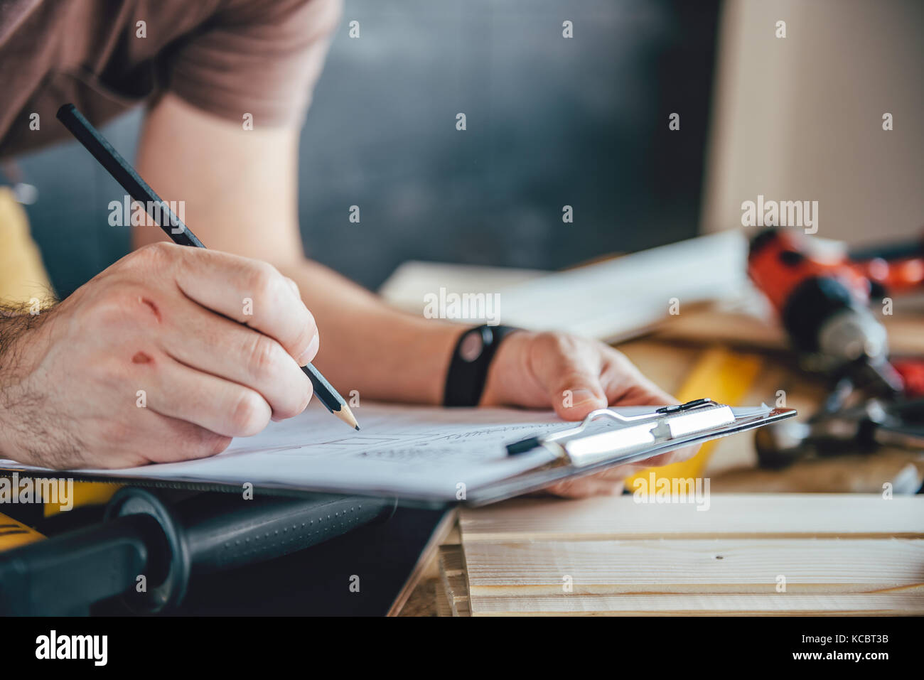 Man making draft plan with pencil on the table with power drills and ...