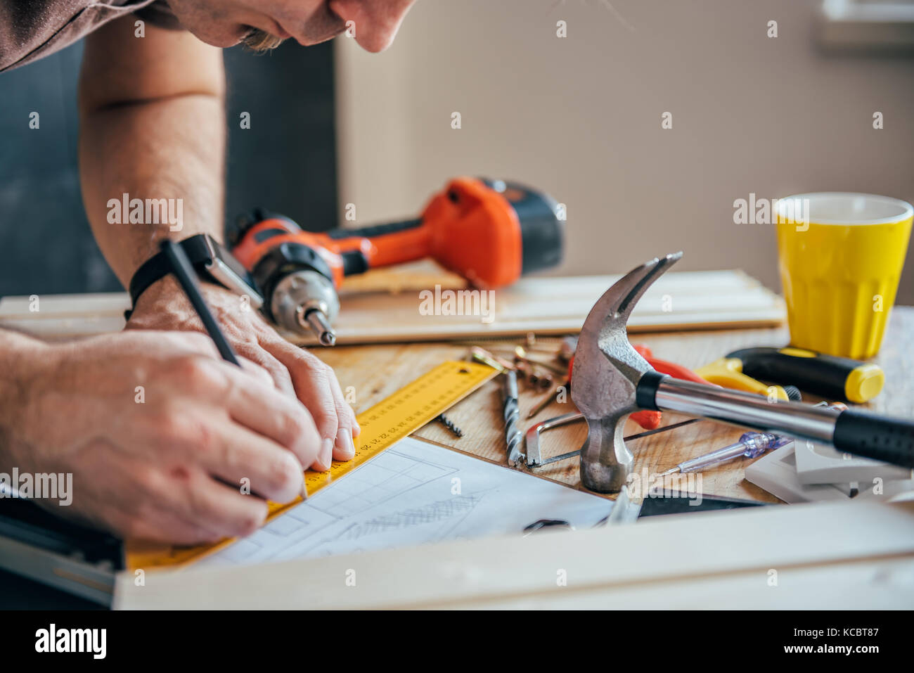 Man making draft plan with pencil on the table with power drills and ...