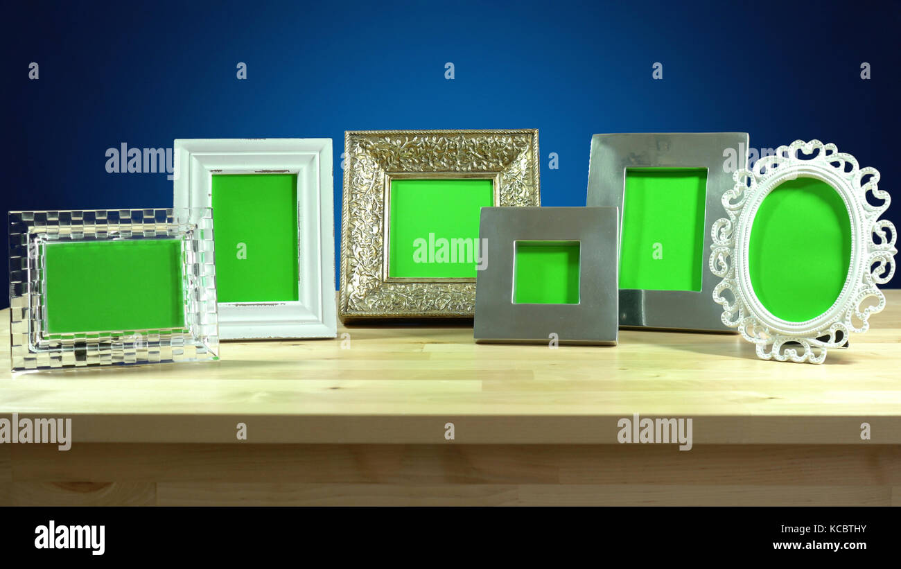 Row of photo frames with blank green screens in elegant table interiors ...