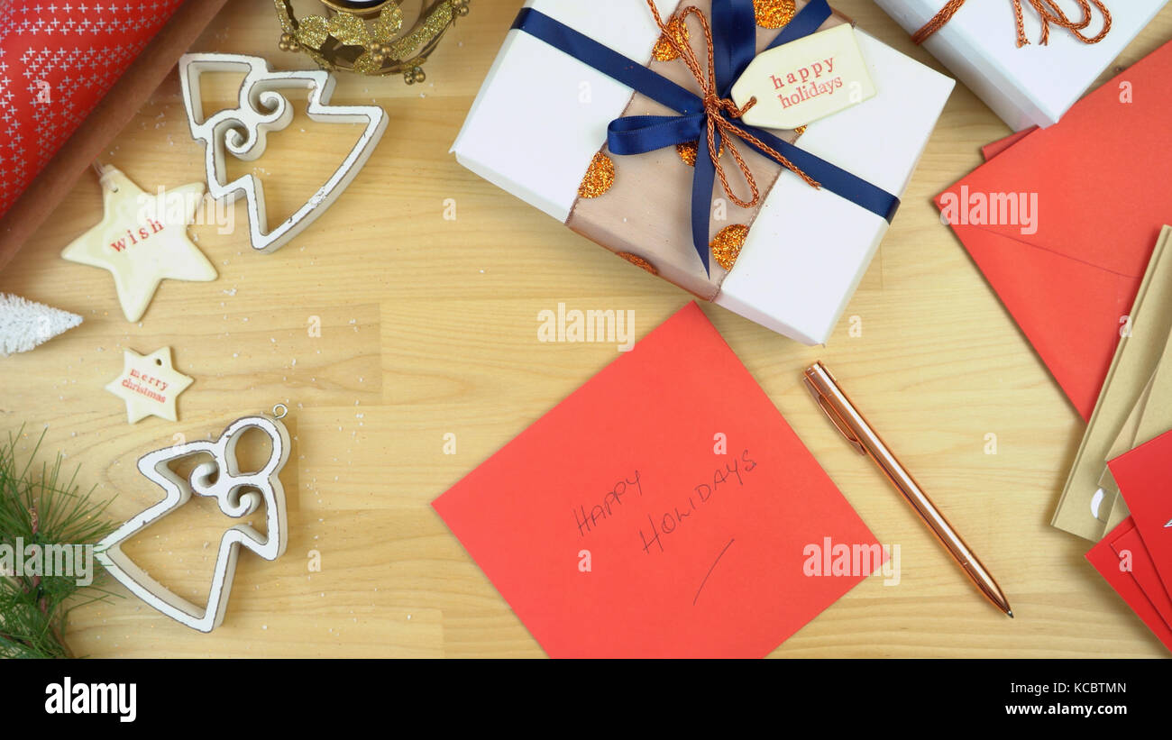 Wrapping gifts and writing Christmas cards overhead Stock Photo - Alamy