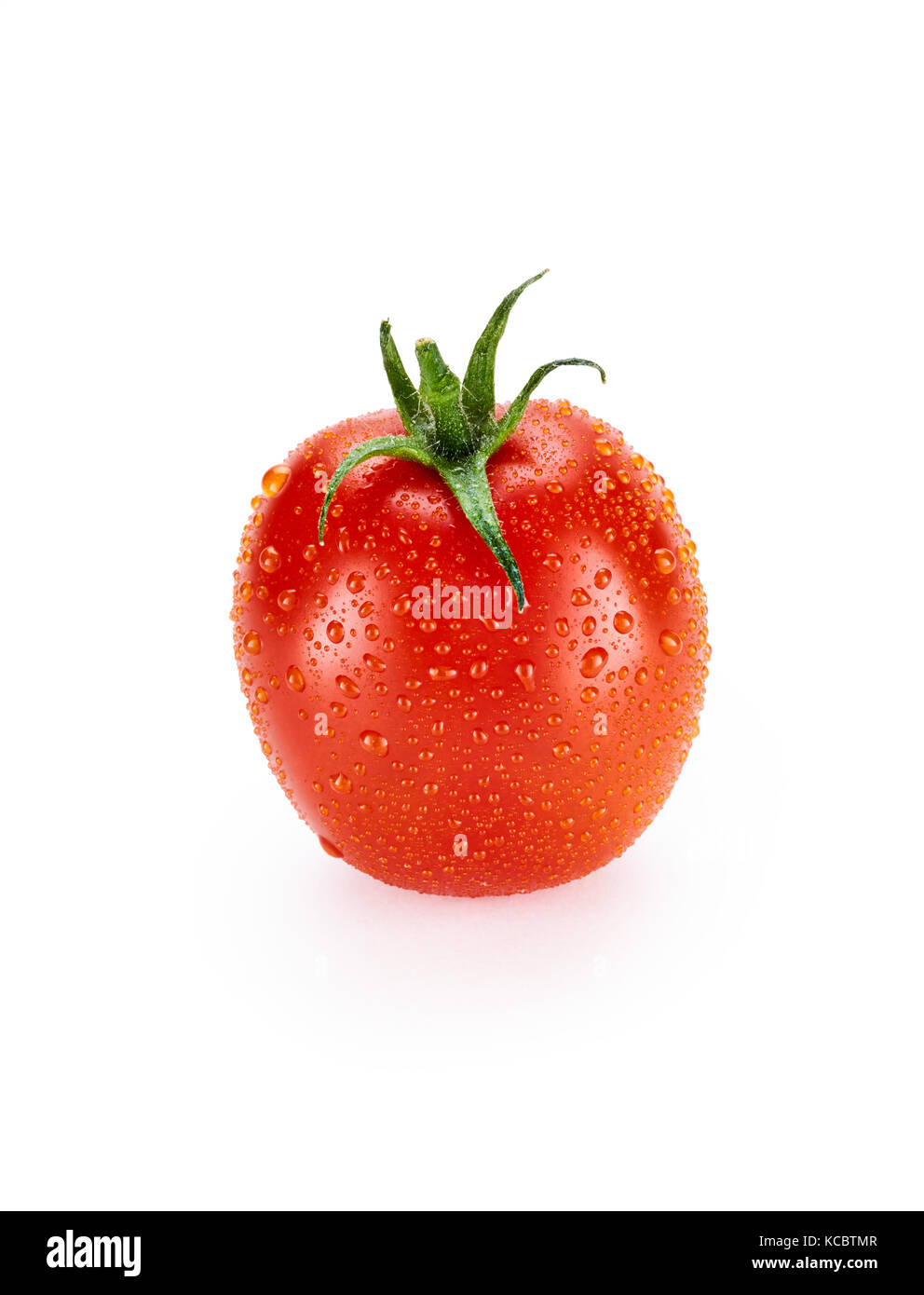 A washed bright red ripe chilled plum tomato isolated on a white ...