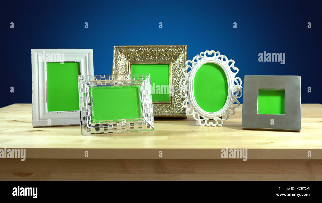 Row of photo frames with blank green screens in elegant table interiors ...