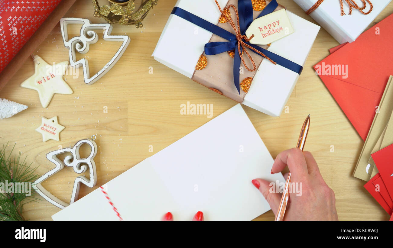 Wrapping gifts and writing Christmas cards overhead Stock Photo - Alamy