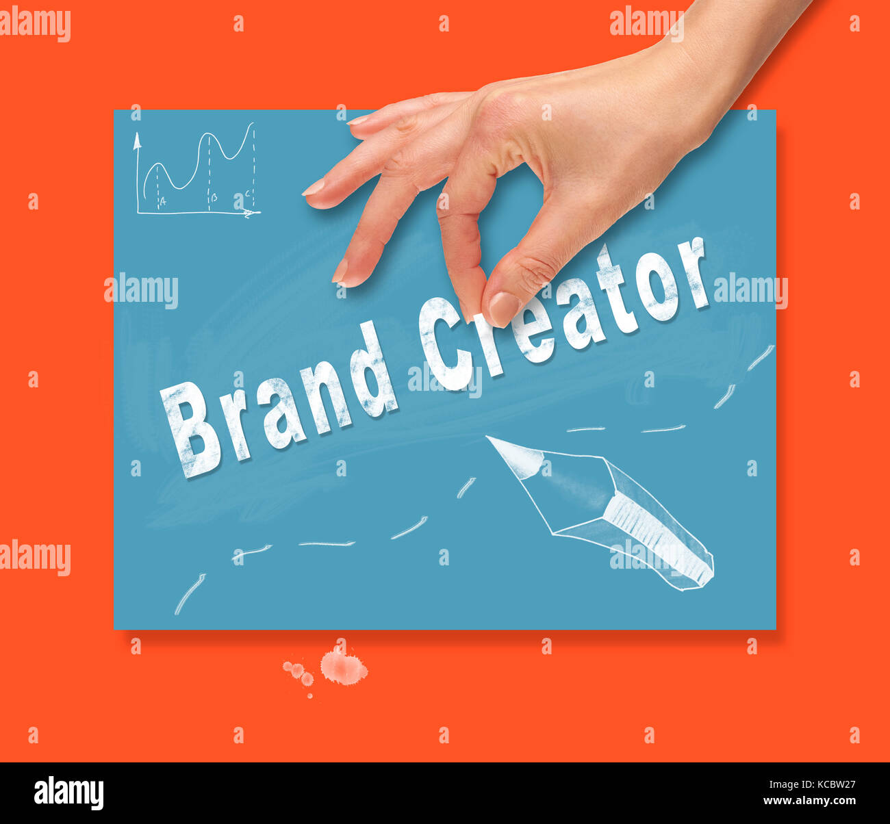 A hand picking up a Brand Creator concept on a colorful drawing board ...