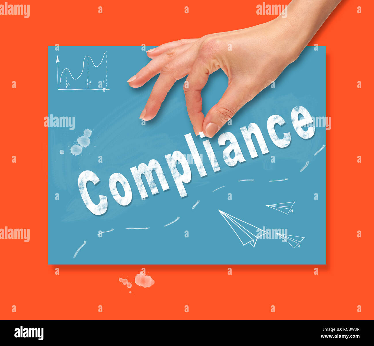 A hand picking up a Compliance concept on a colorful drawing board ...
