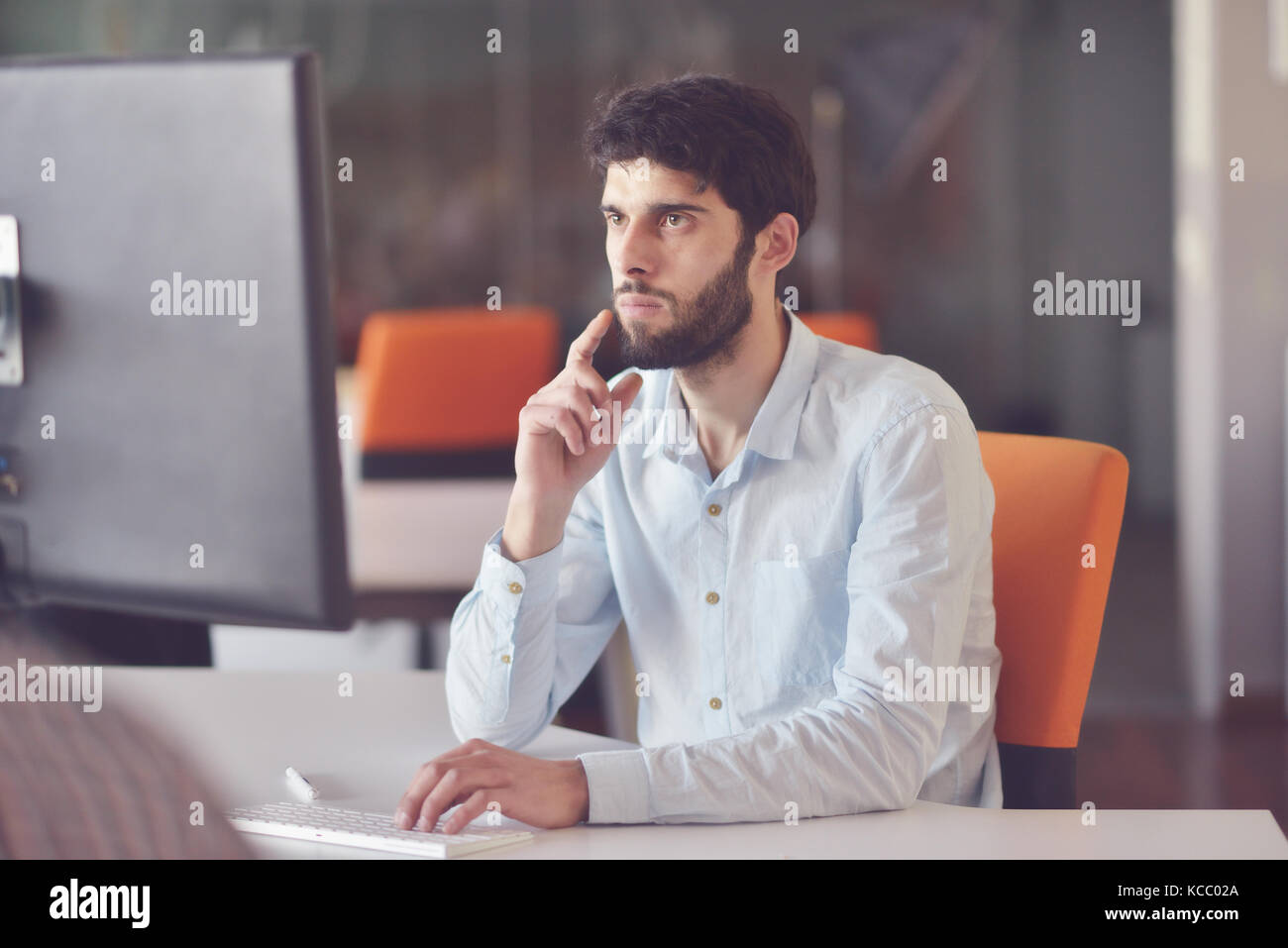 young business man working on desktop computer at his desk in modern ...