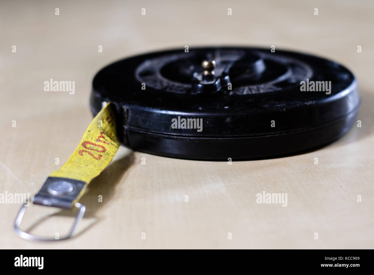 Tape for measuring in the field. A measure tangled on a wooden table ...