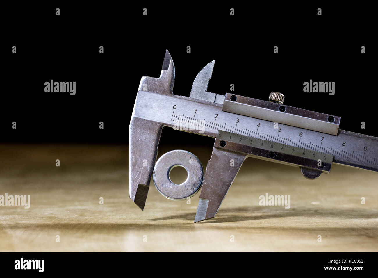 Old good caliper in hand while measuring the abdomen. Wooden table ...