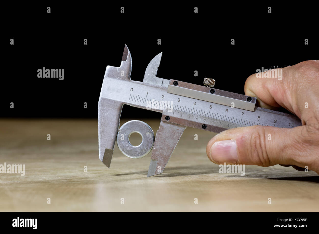 Old good caliper in hand while measuring the abdomen. Wooden table ...