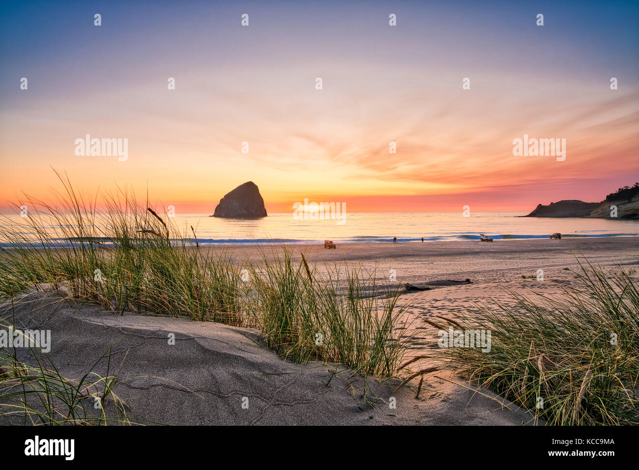 The sun sets over Haystack Rock at Cape Kiwanda, Pacific City, Oregon ...