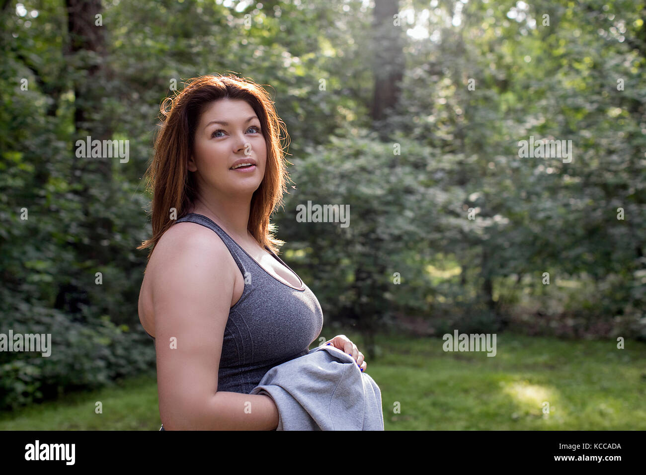 Young woman standing in summer park Stock Photo - Alamy