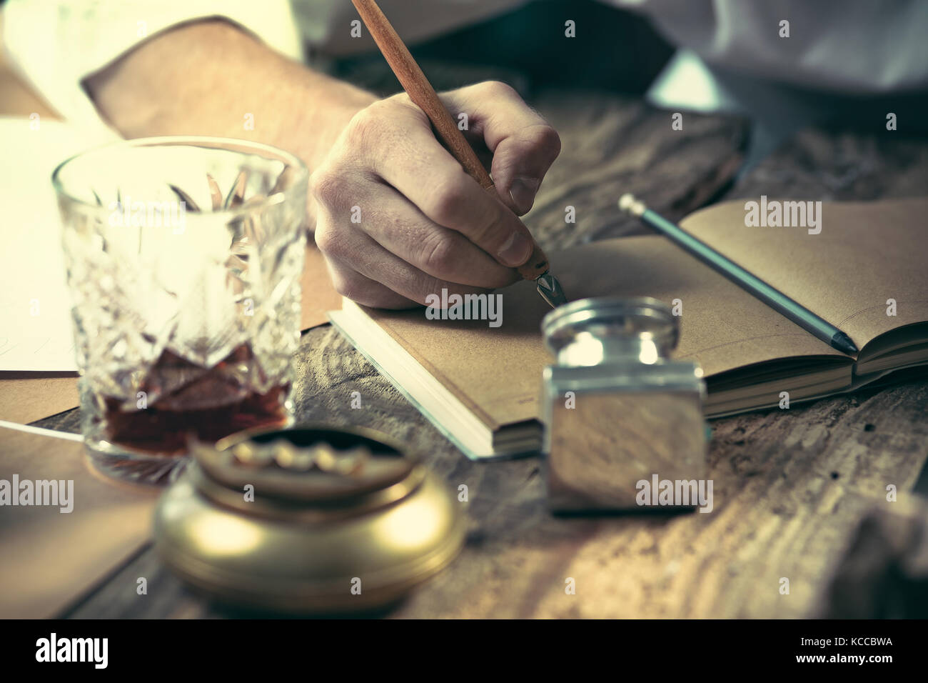 Writer at work. The hands of young writer sitting at the table and ...