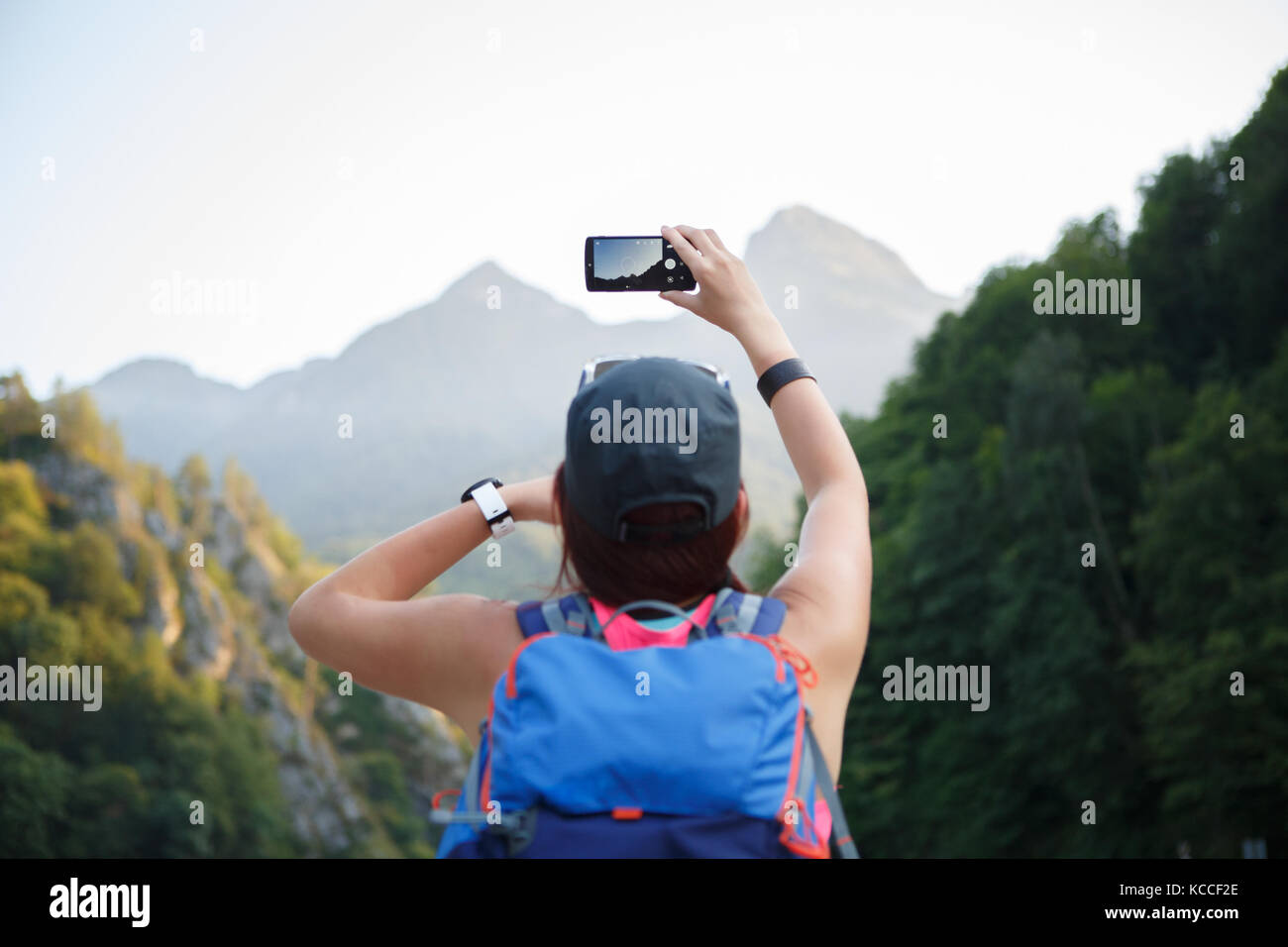 Photo from back of girl with backpack with smartphone Stock Photo - Alamy