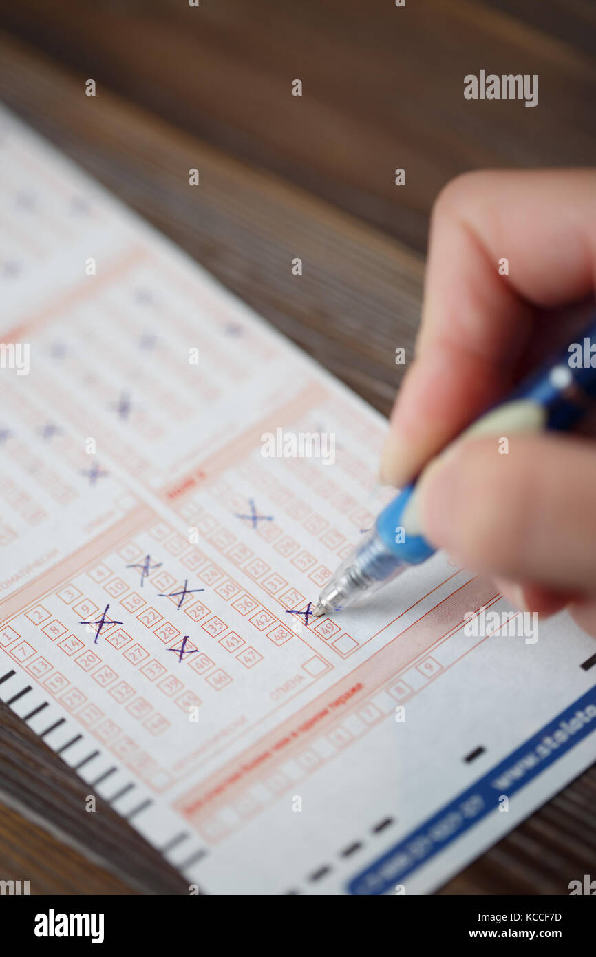 Close-up photo of man marking in lottery ticket Stock Photo - Alamy