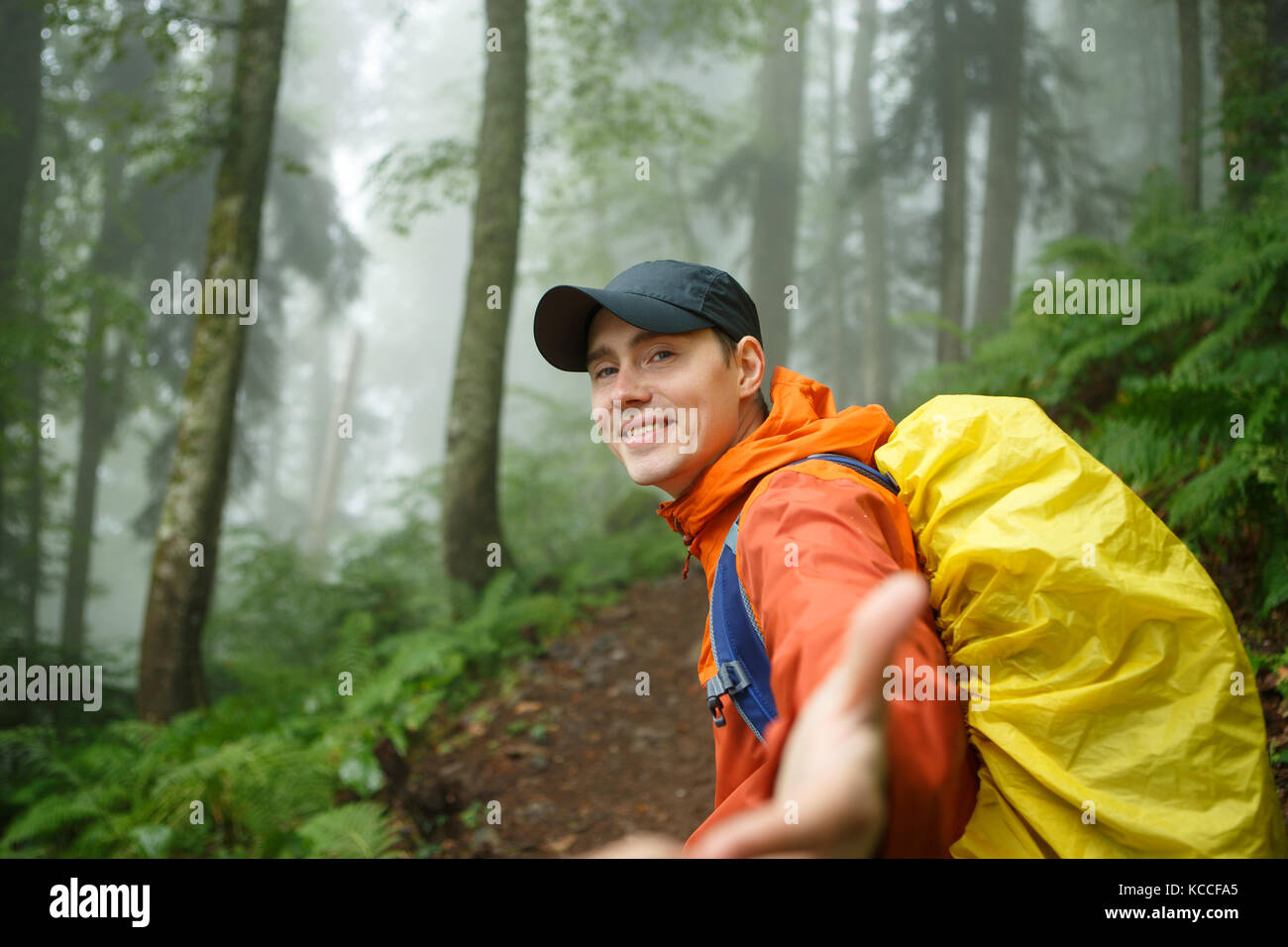 Photo of young man with backpack stretching arm Stock Photo - Alamy
