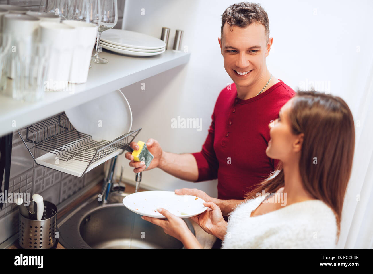 Happy loving young couple washing the dishes in the kitchen Stock Photo ...