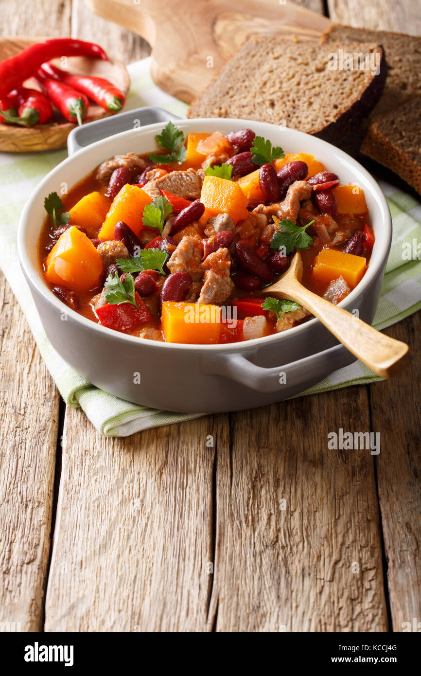 Stew with beef, pumpkin, red beans, tomatoes and chilli close-up in a ...