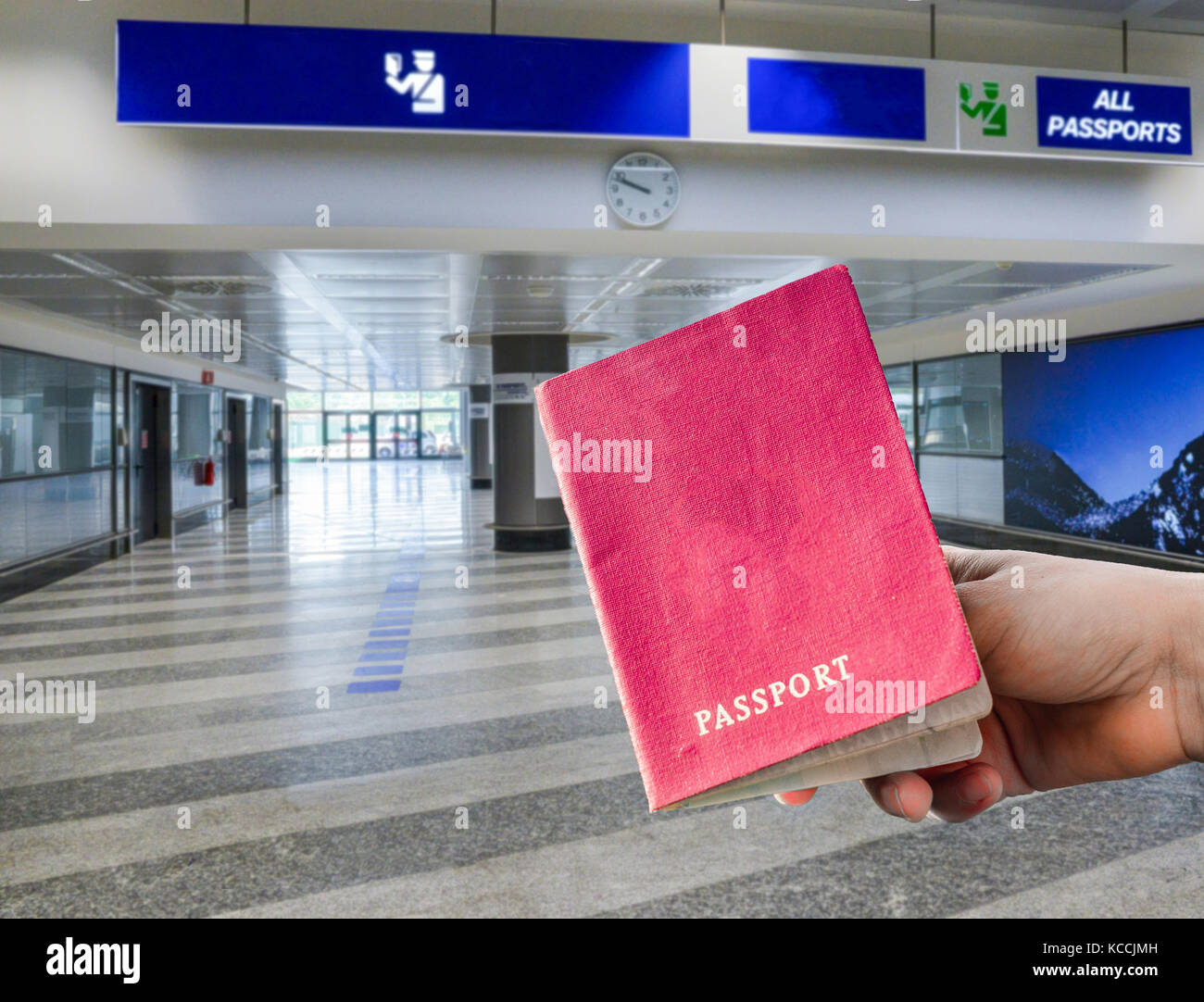 Person holding generic passport in airport passport control area ...