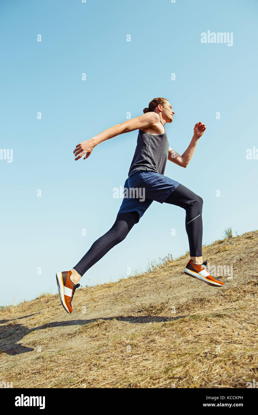 Running sport. Man runner sprinting outdoor in scenic nature. Fit ...