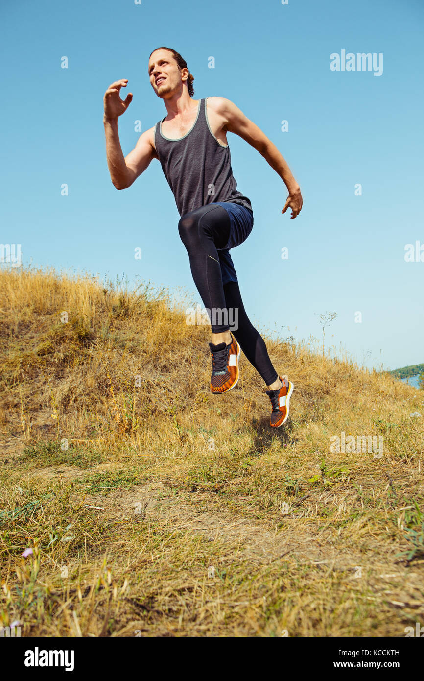 Running sport. Man runner sprinting outdoor in scenic nature. Fit ...