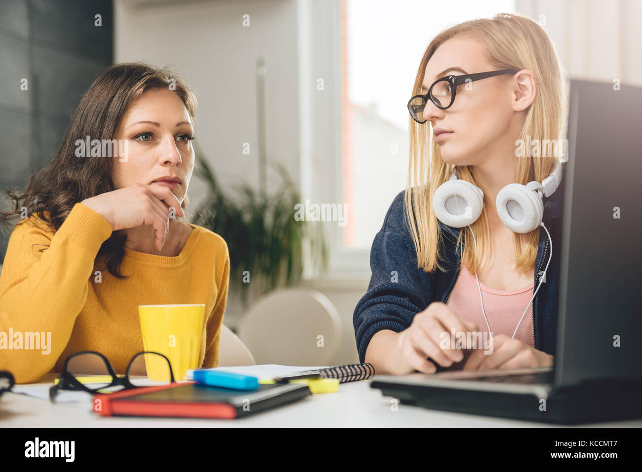 Two business woman using computer at the office and discussing Stock ...