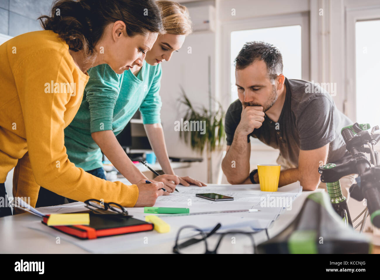Group of people checking blueprints in the office Stock Photo - Alamy