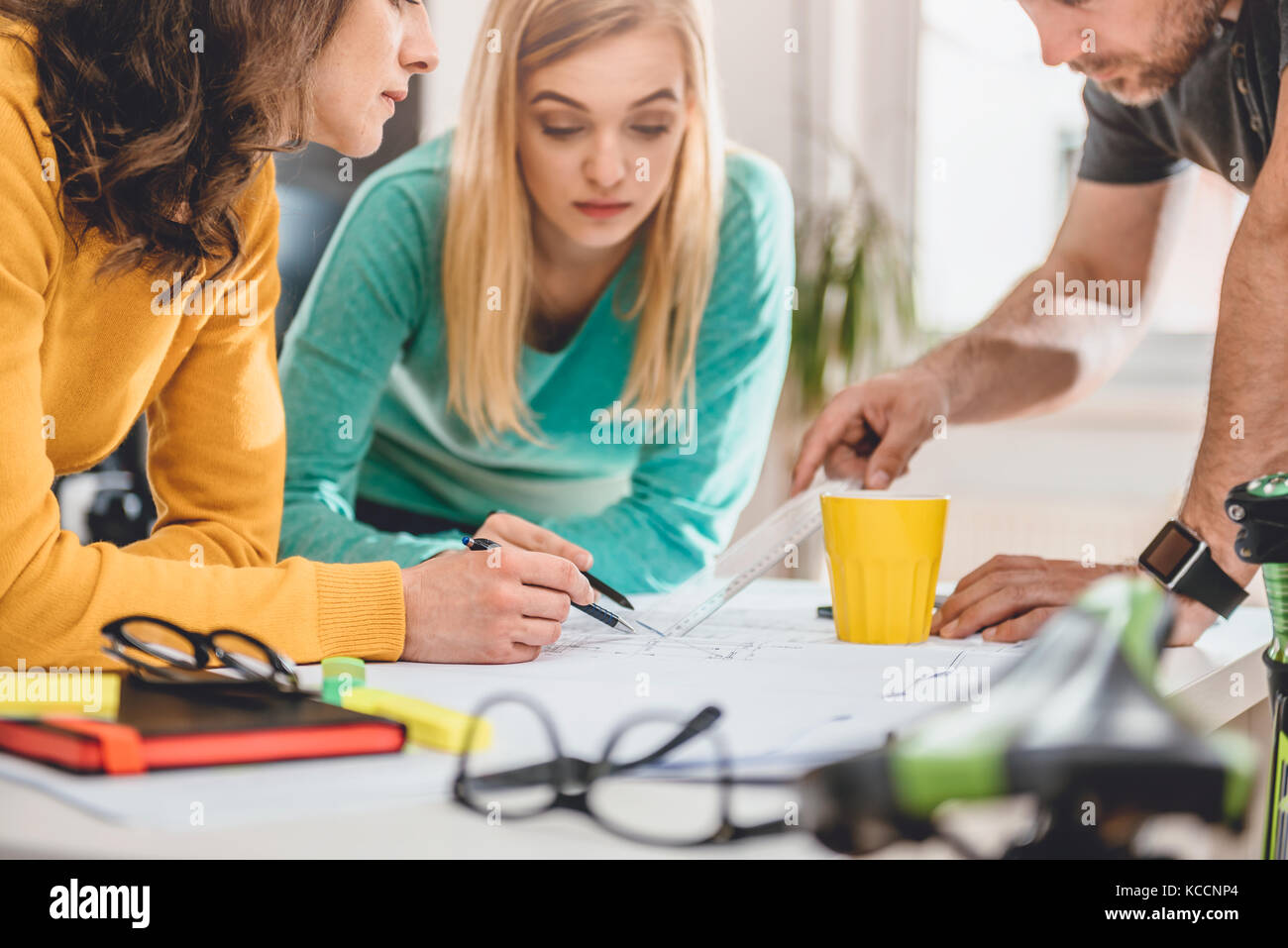 Group of people checking blueprints in the office Stock Photo - Alamy
