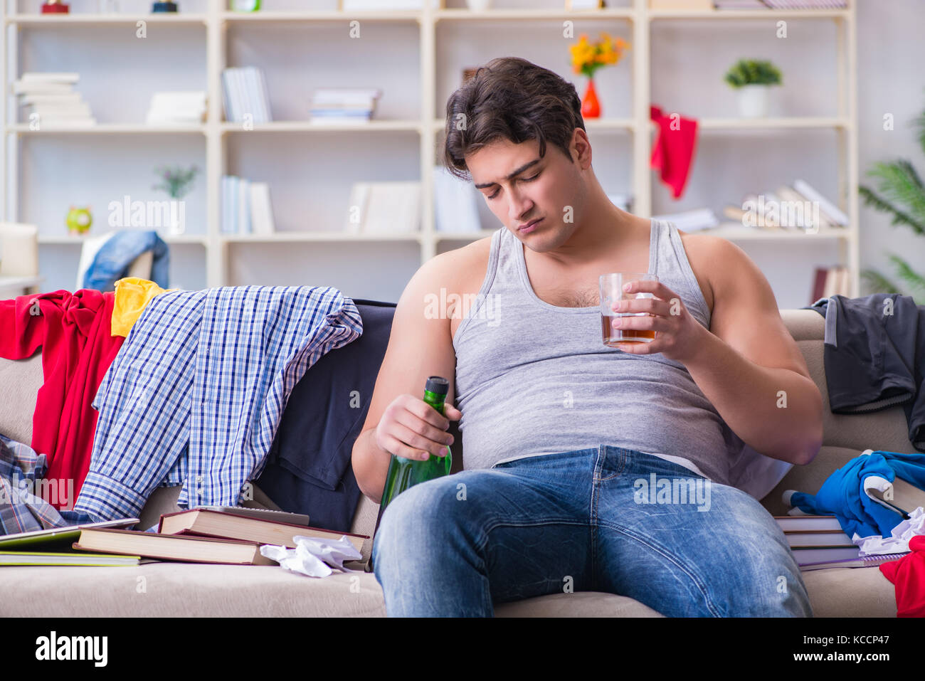 Young man student drunk drinking alcohol in a messy room Stock Photo ...