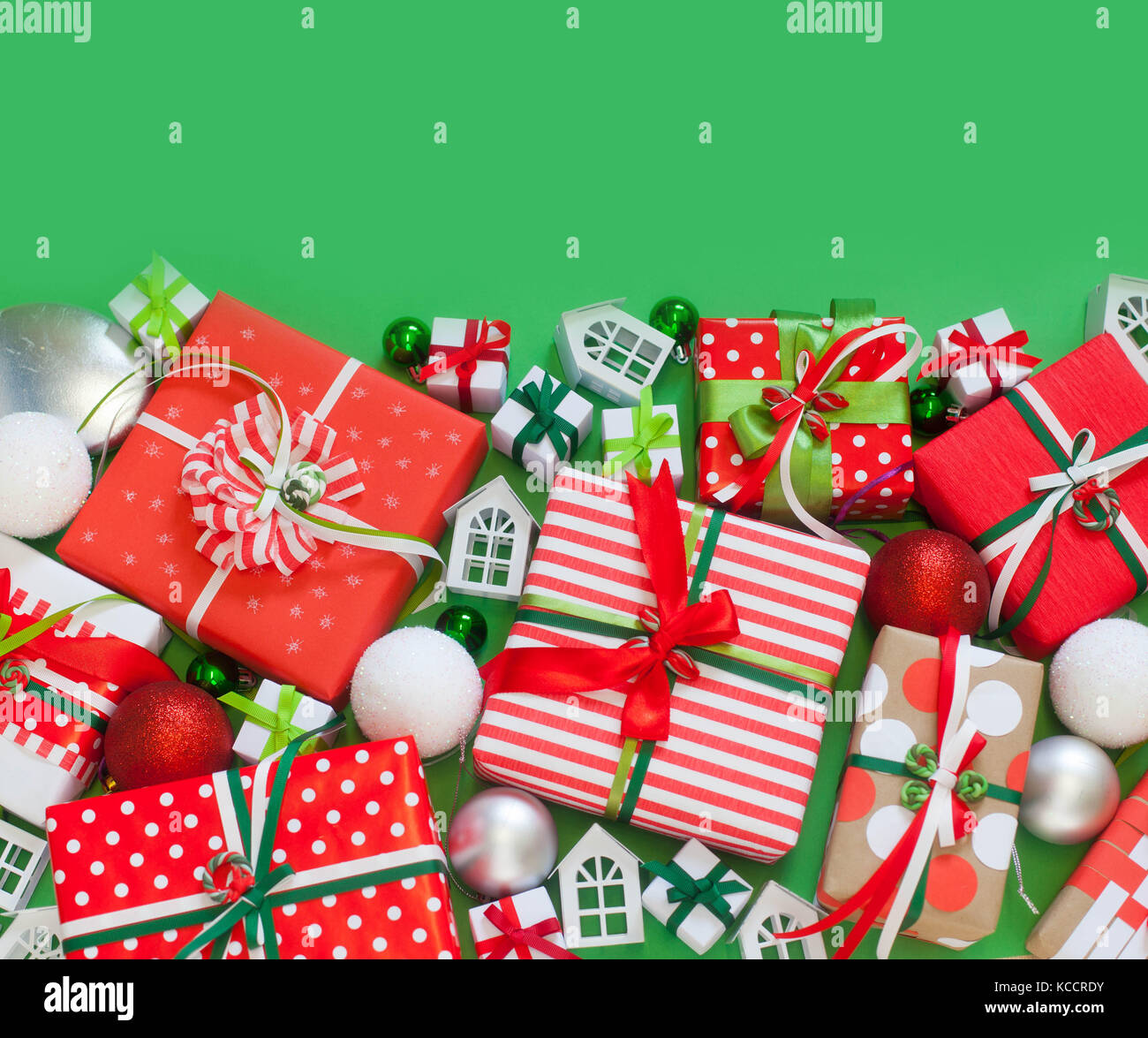 Christmas presents in red packaging. Satin colored ribbons. Green ...