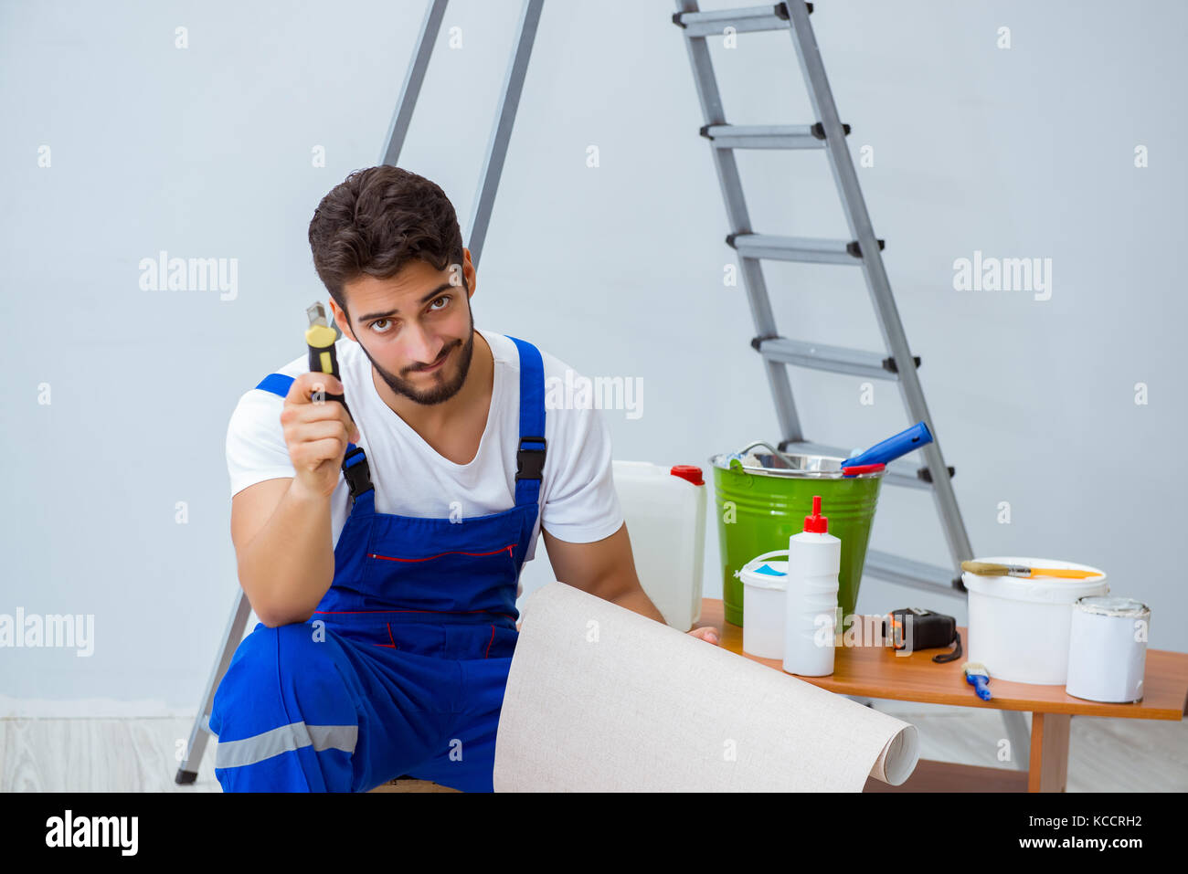 Repairman doing renovation repair in the house with paper wallpaper ...