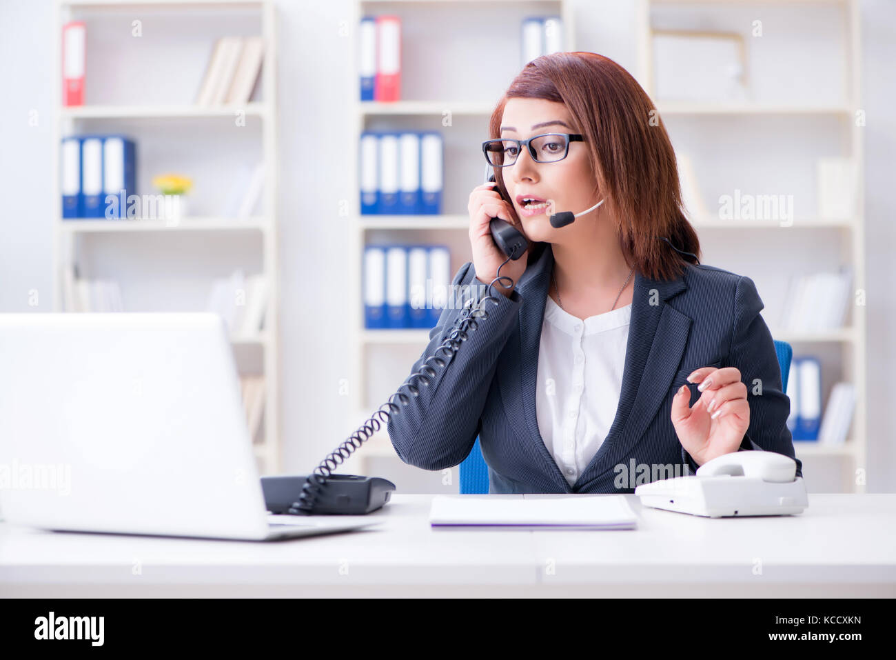 Frustrated call center assistant responding to calls Stock Photo - Alamy