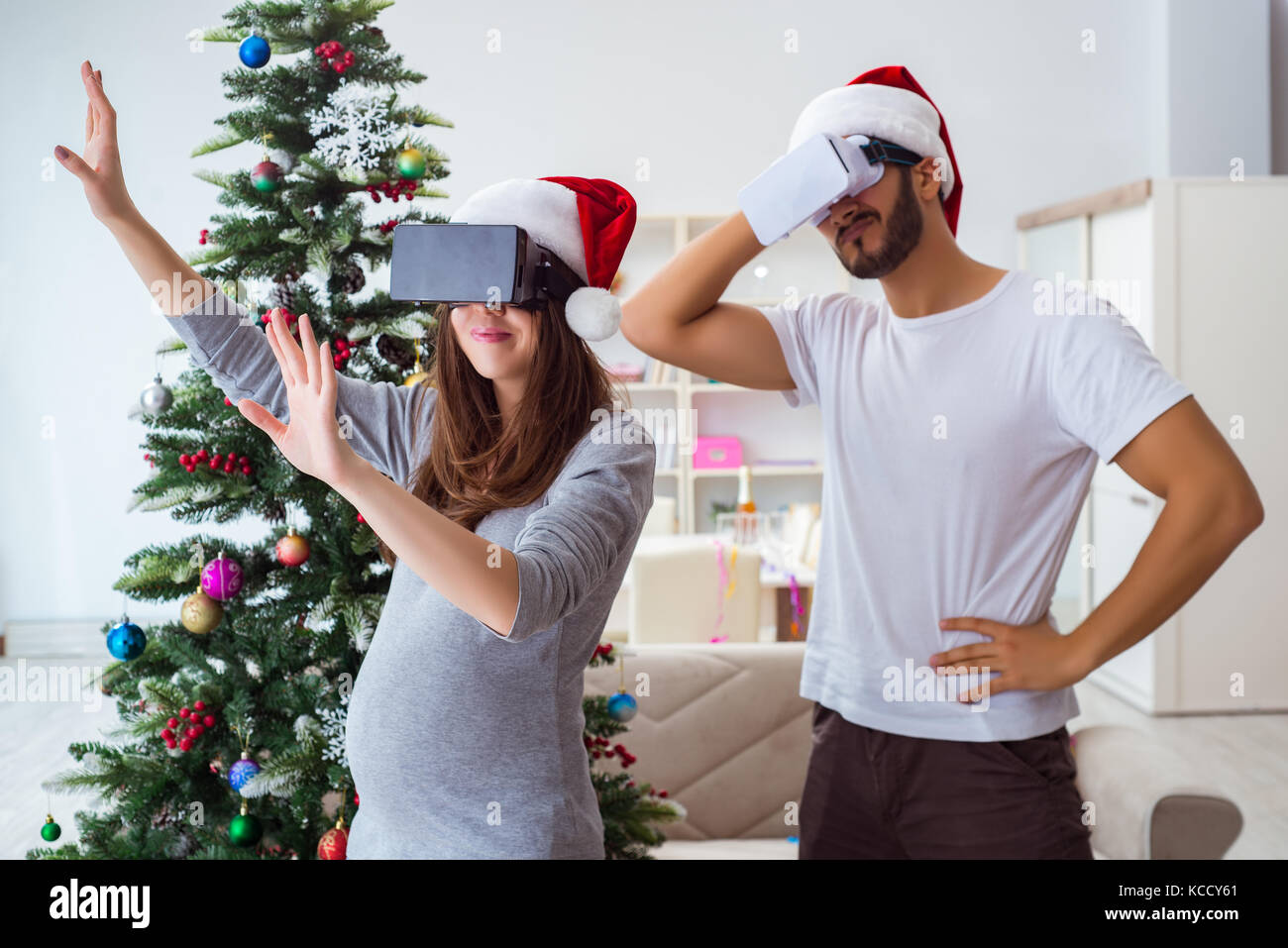 Young family expecting child baby wearing virtual reality VR glasses ...