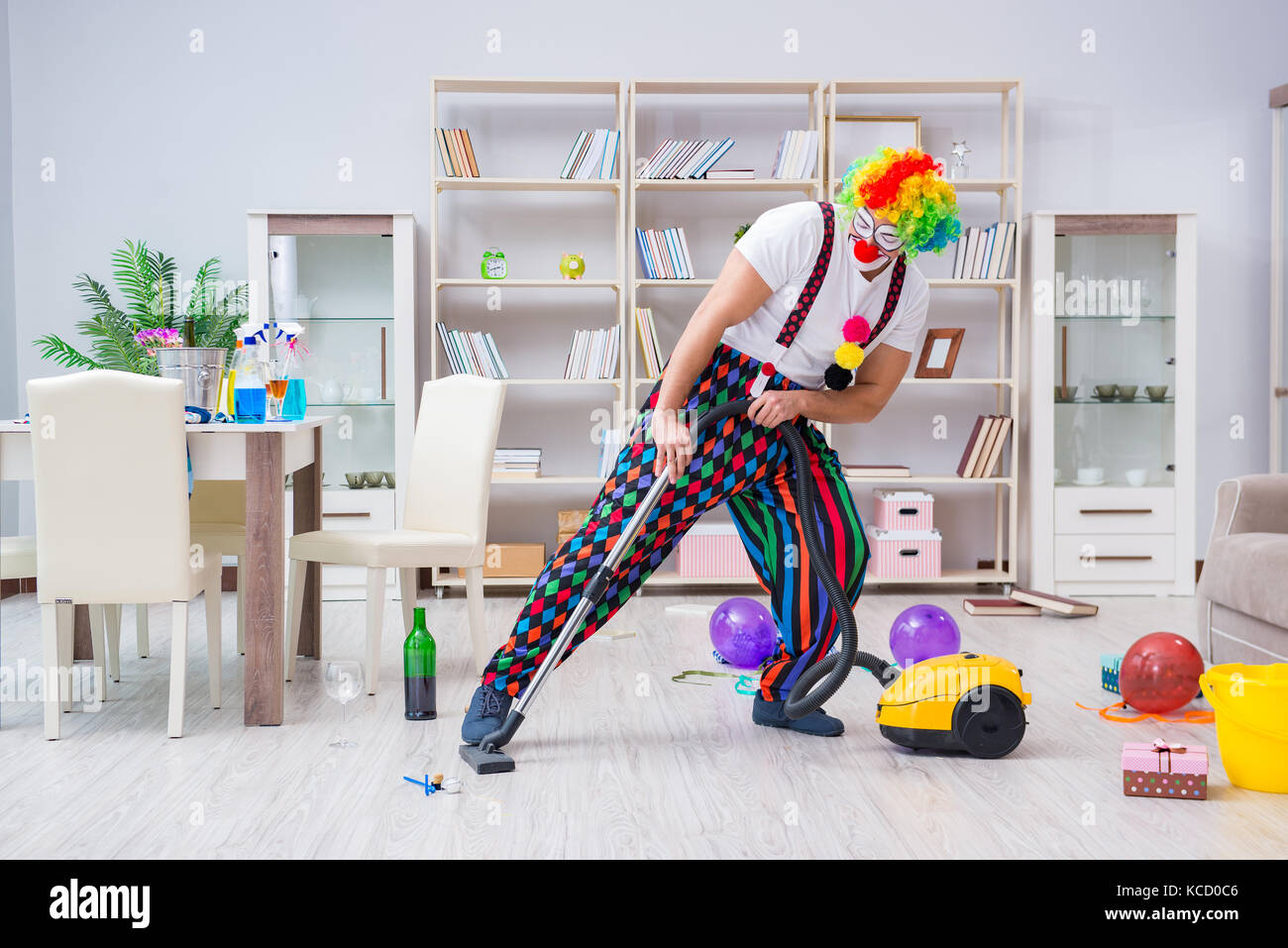 Funny clown doing cleaning at home Stock Photo - Alamy