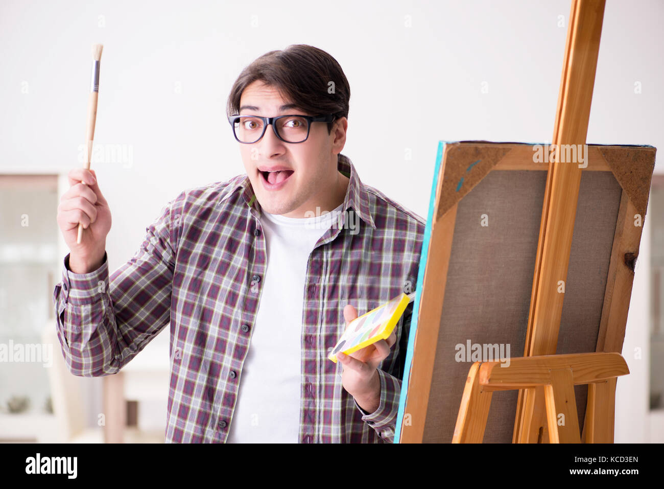 Young male artist drawing pictures in bright studio Stock Photo - Alamy