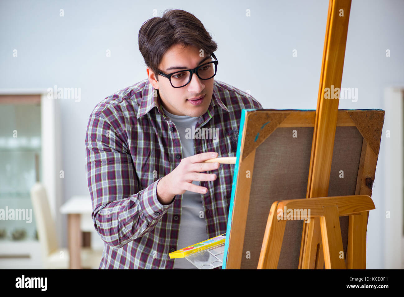 Young male artist drawing pictures in bright studio Stock Photo - Alamy