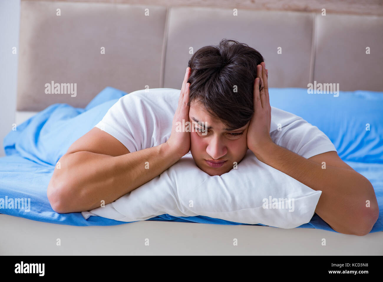 Man suffering from insomnia lying in bed Stock Photo - Alamy