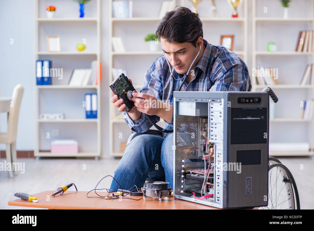 Computer repairman on wheelchair working Stock Photo - Alamy