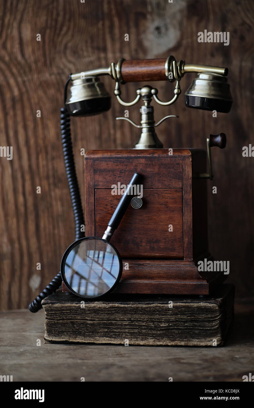 Old telephone and retro book on a wood Stock Photo - Alamy