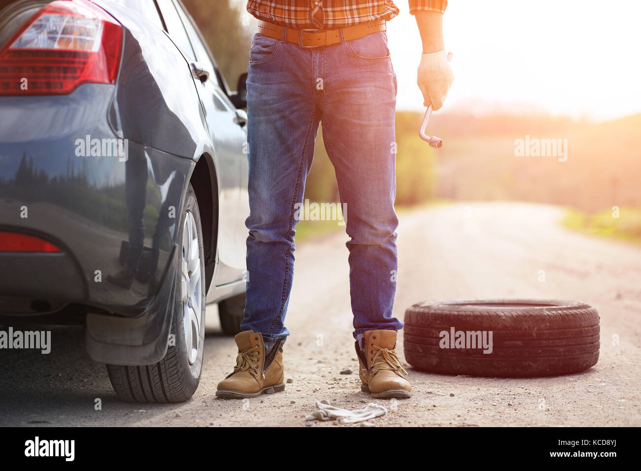 Man is sitting on the road by the car Stock Photo - Alamy