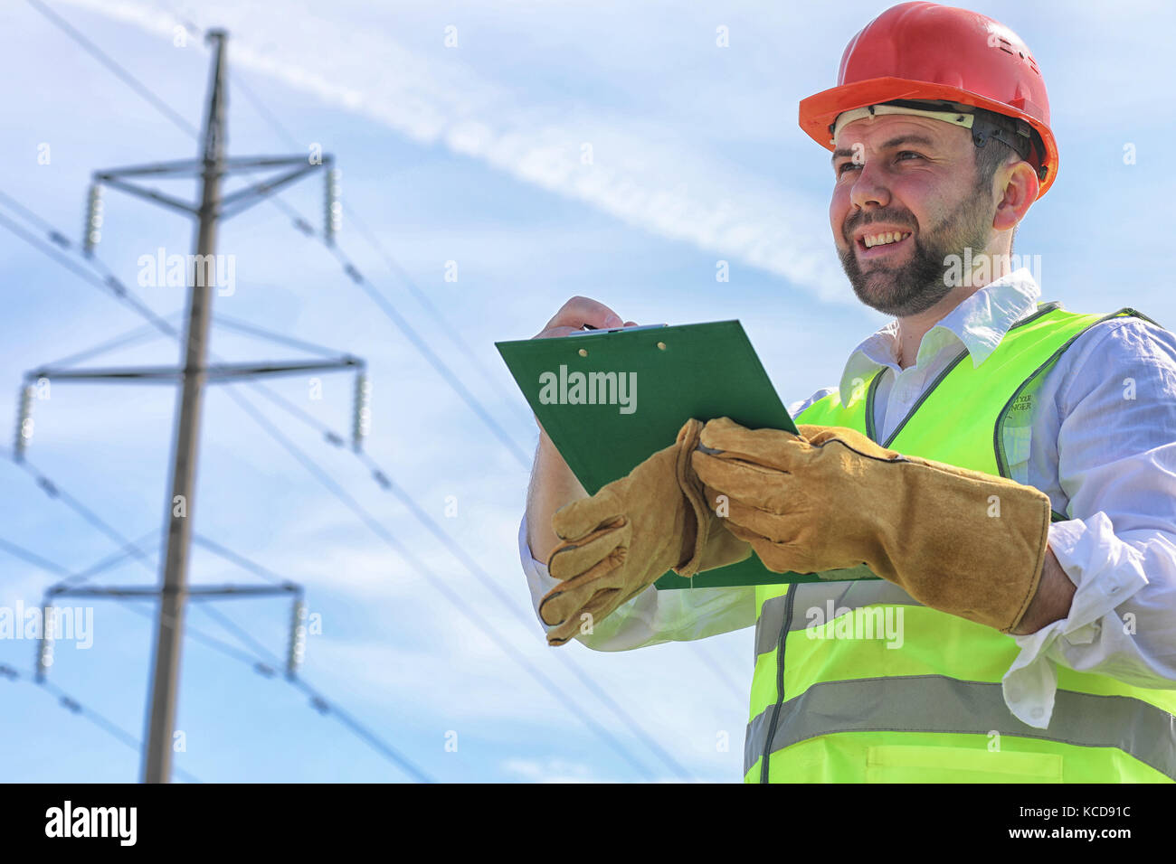 Electrician working in a helmet wearing gloves Stock Photo - Alamy