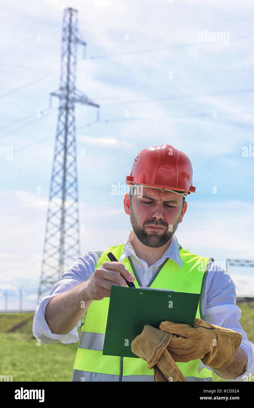 Electrician working in a helmet wearing gloves Stock Photo - Alamy