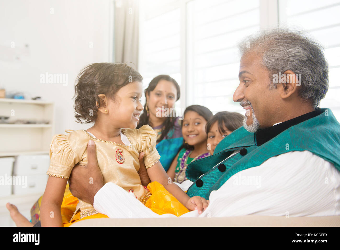 Portrait of happy Indian family sitting on couch at home. Asian people ...